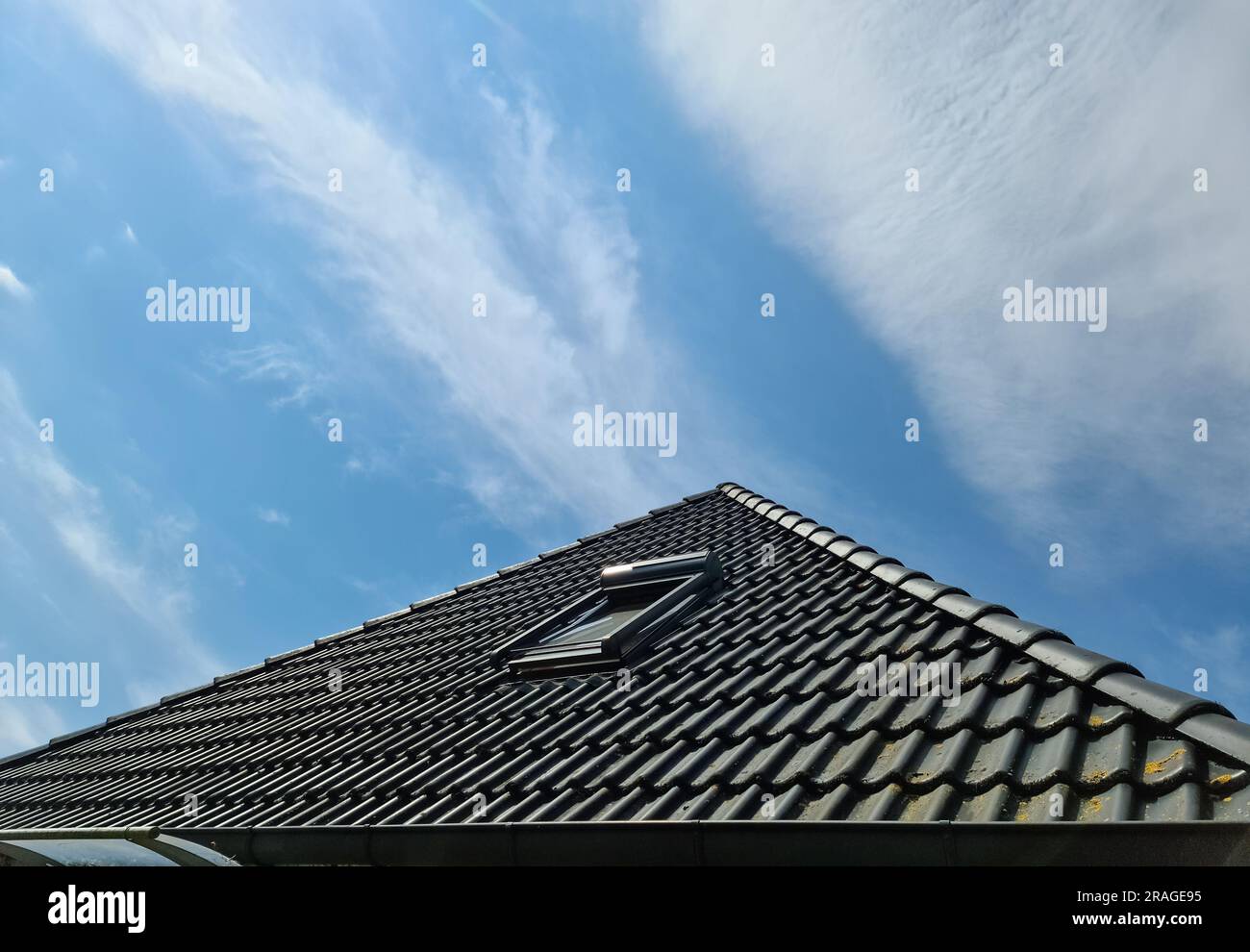 Open roof window in velux style with black roof tiles Stock Photo - Alamy