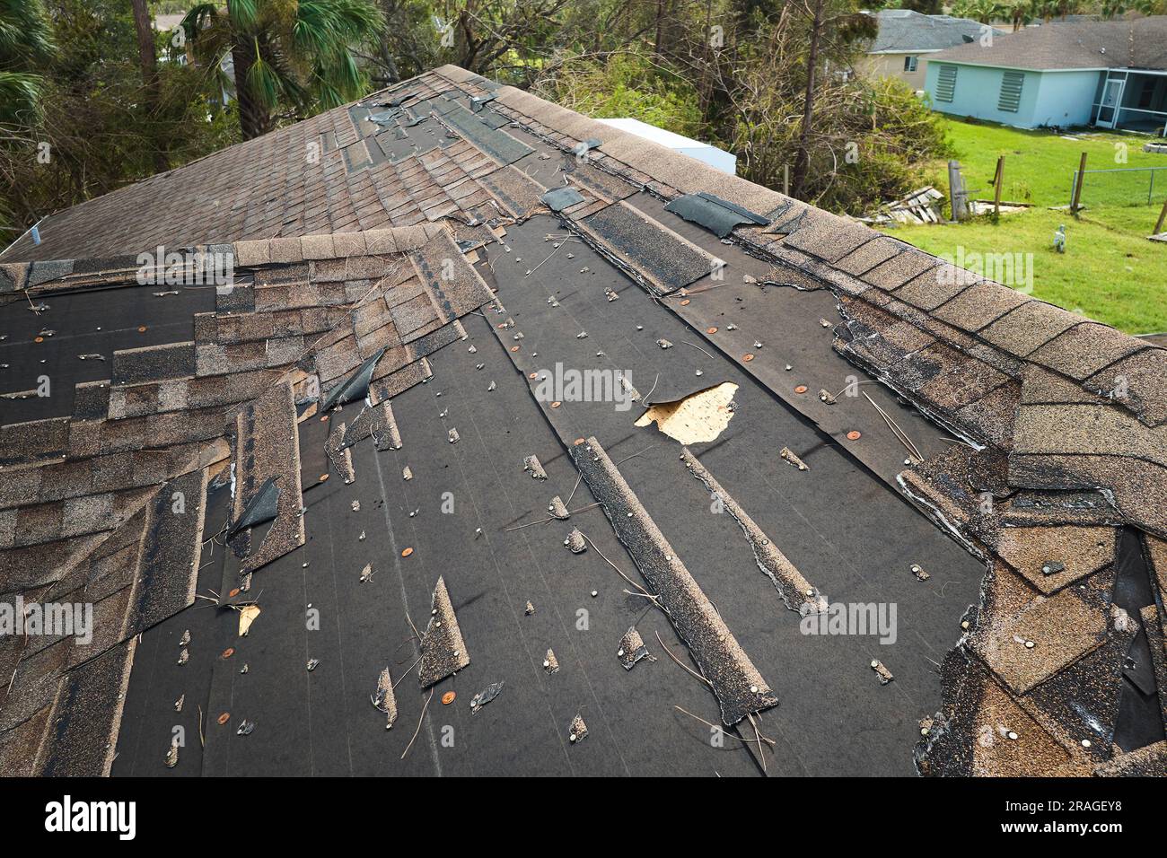 Damaged house roof with missing shingles after hurricane Ian in Florida ...