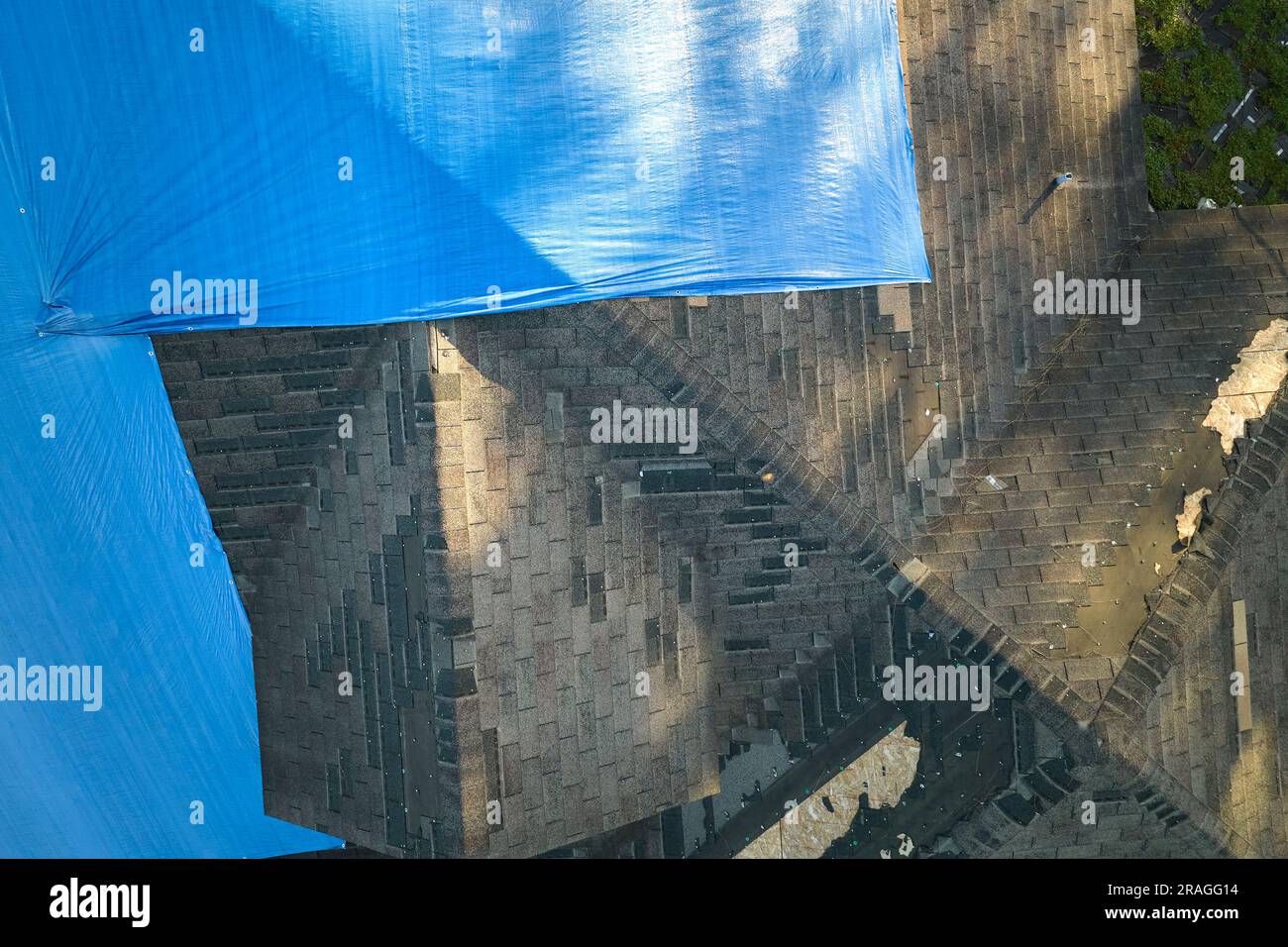 Top view of leaking house roof covered with protective tarp sheets ...