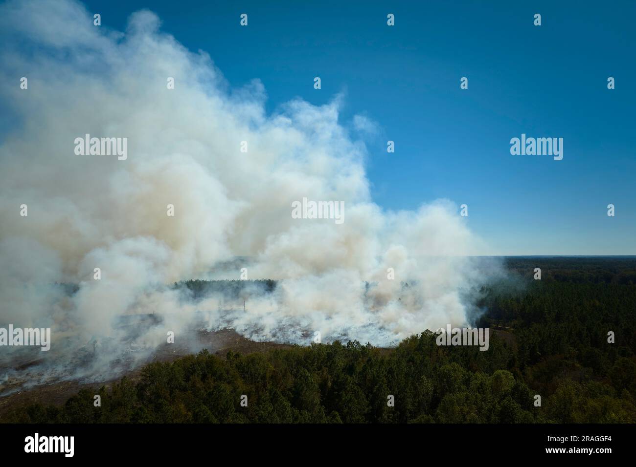 View from above of dense smoke from woodland and field on fire rising ...