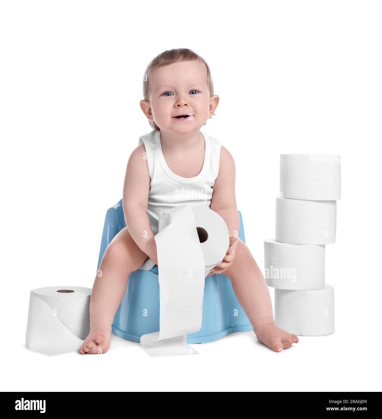 Little child sitting on baby potty and stack of toilet paper rolls ...