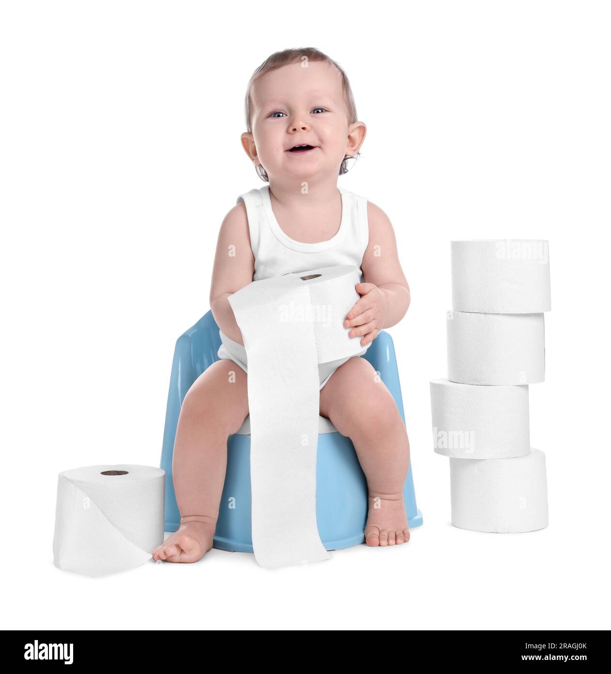 Little child sitting on baby potty and stack of toilet paper rolls ...