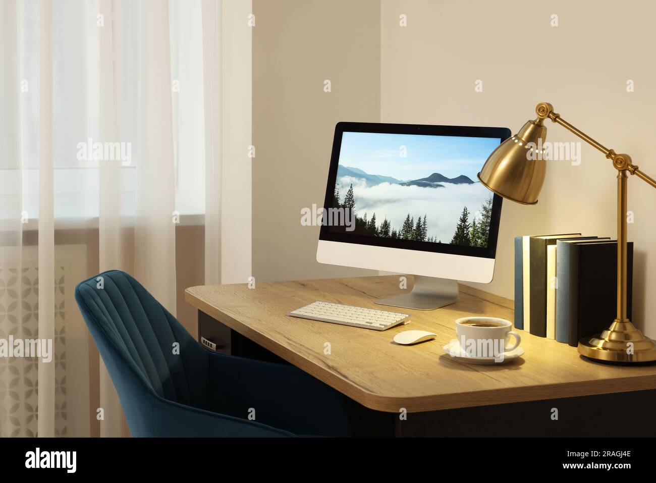 Cozy workspace with computer on wooden desk and comfortable chair at ...