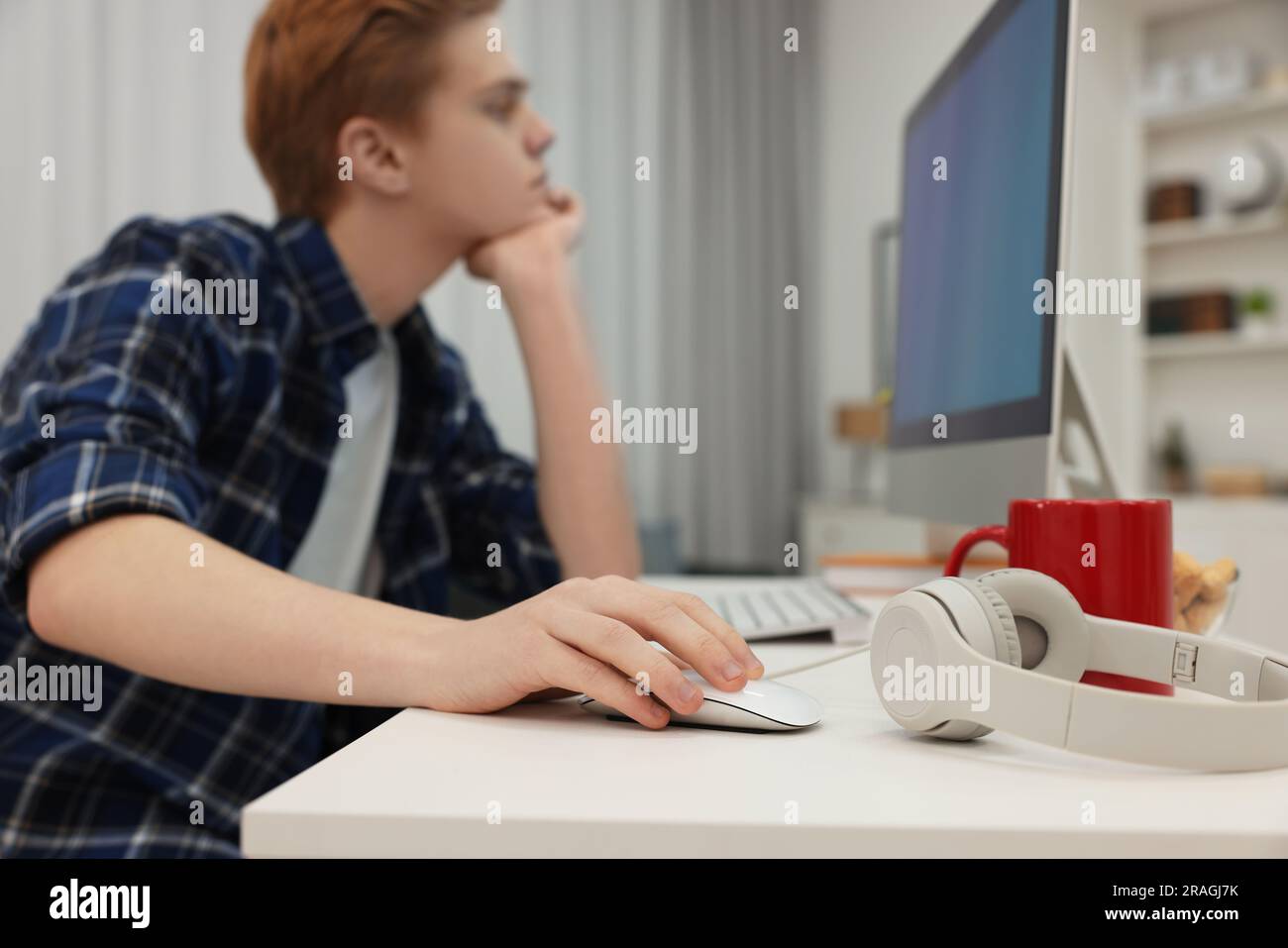 Teenage boy using computer in room, focus on hand. Internet addiction ...