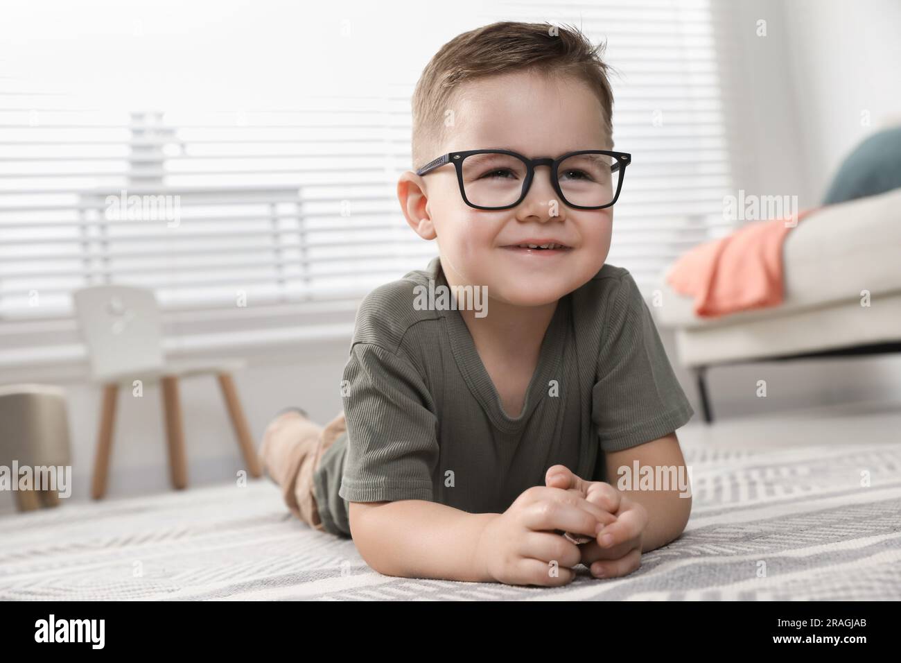 Cute little boy in glasses on floor at home. Space for text Stock Photo ...