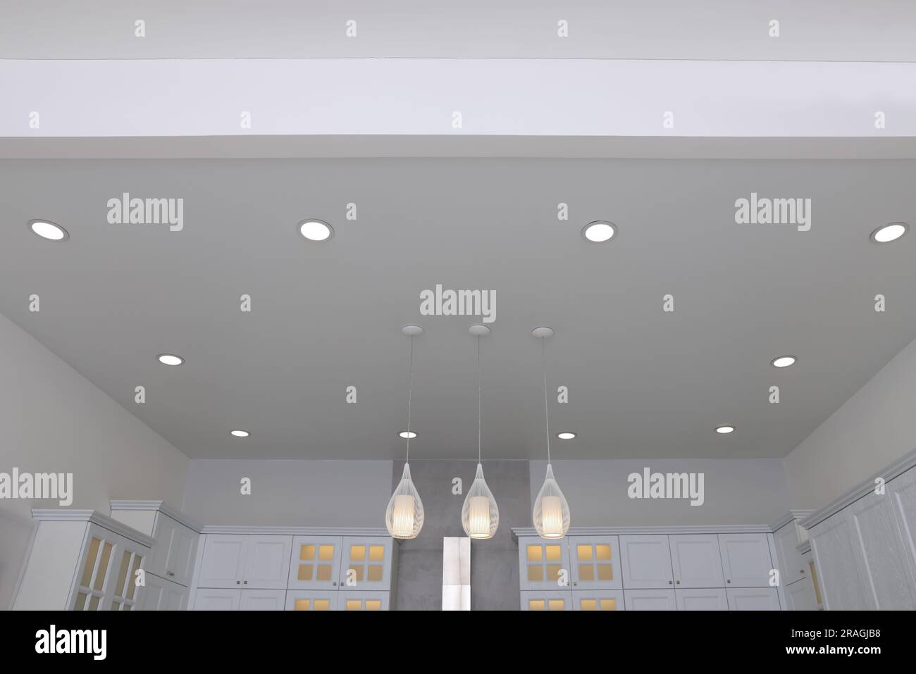 Ceiling with modern lamps and furniture in stylish kitchen, low angle ...
