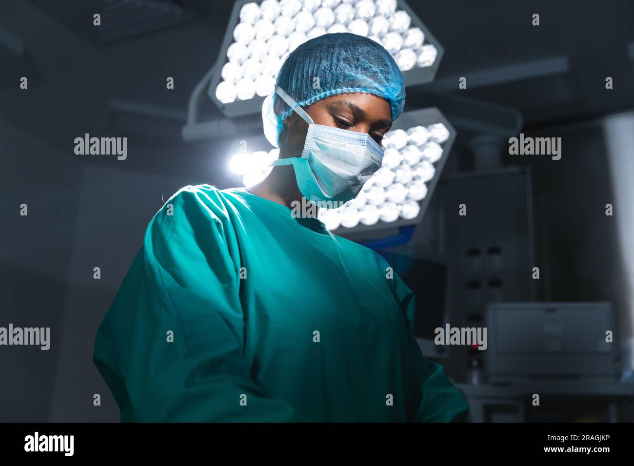 African american female surgeon wearing surgical gown and face mask in ...