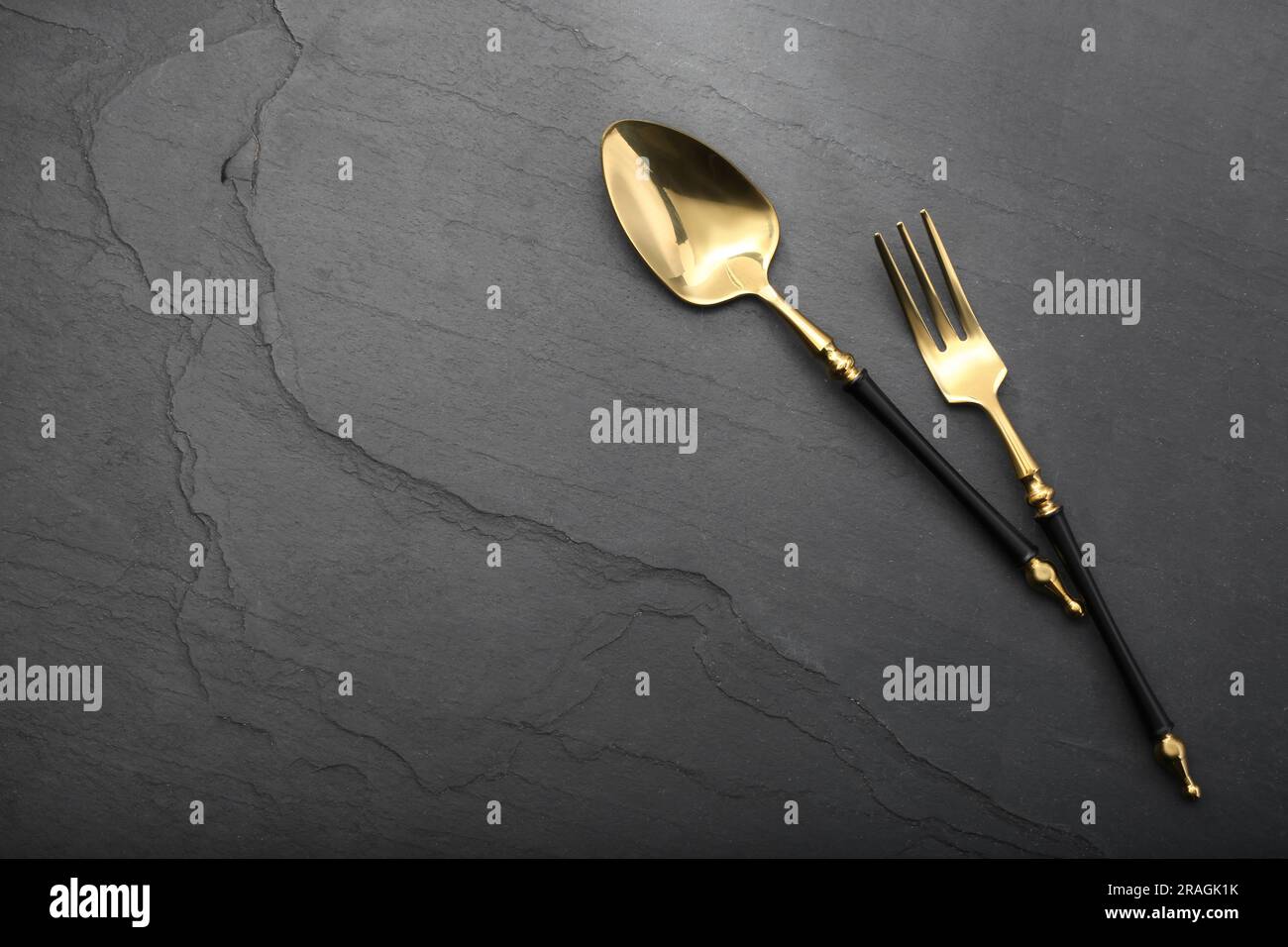 Shiny fork and spoon on black table, flat lay. Space for text Stock ...