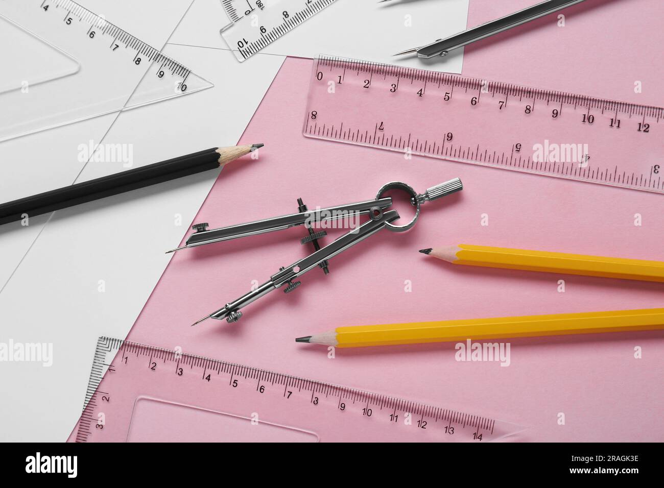 Different rulers, pencils and compass on pink background, above view ...