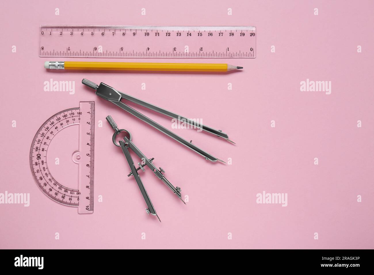 Different rulers, pencil and compasses on pink background, flat lay ...