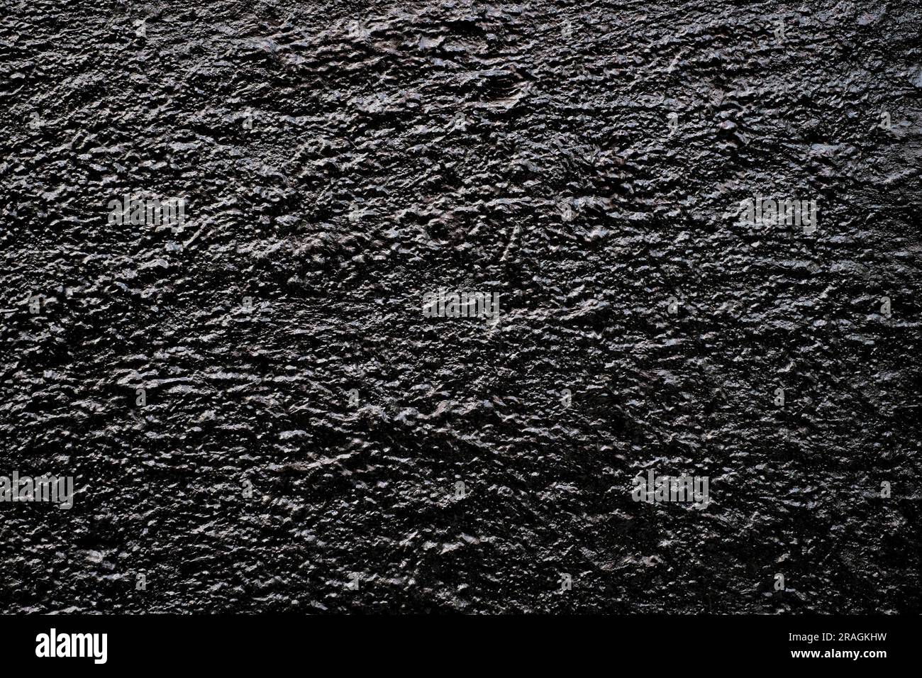 Tar black dimpled black surface in side light, old dungeon wall Stock ...