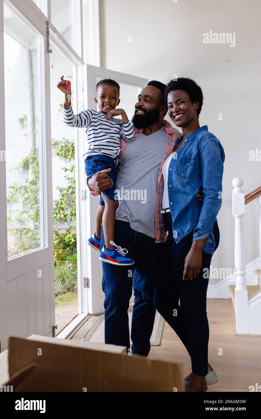 Happy african american parents carrying cute son holding key while ...