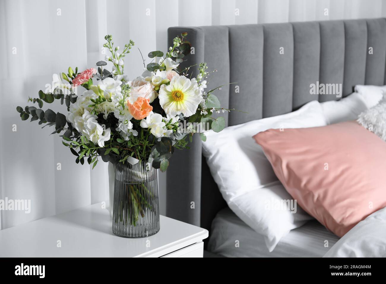 Bouquet of beautiful flowers on nightstand in bedroom Stock Photo - Alamy