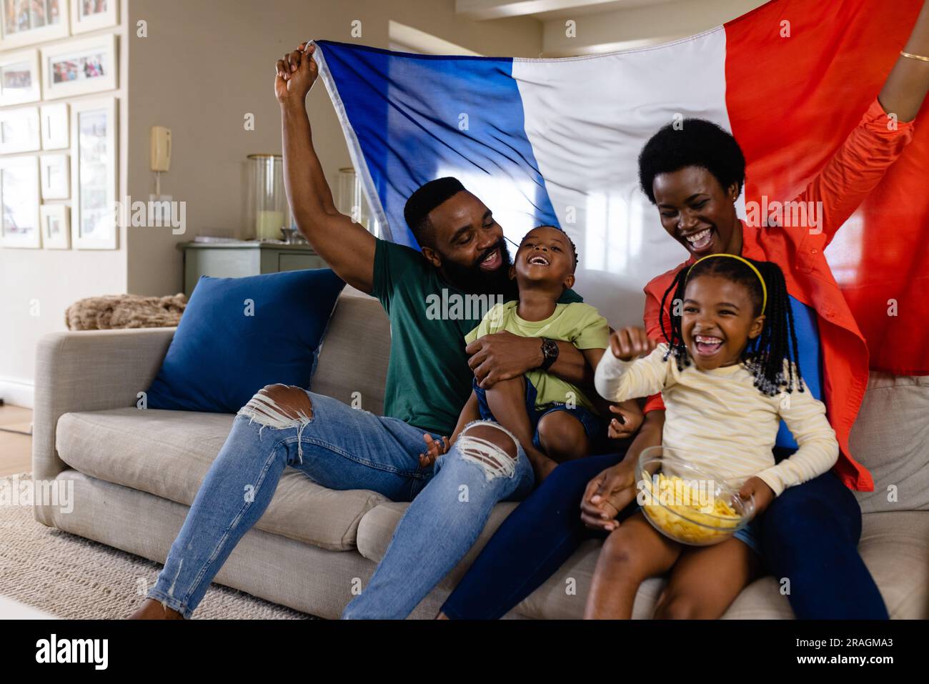 Happy african american parents with son and daughter with flag watching ...