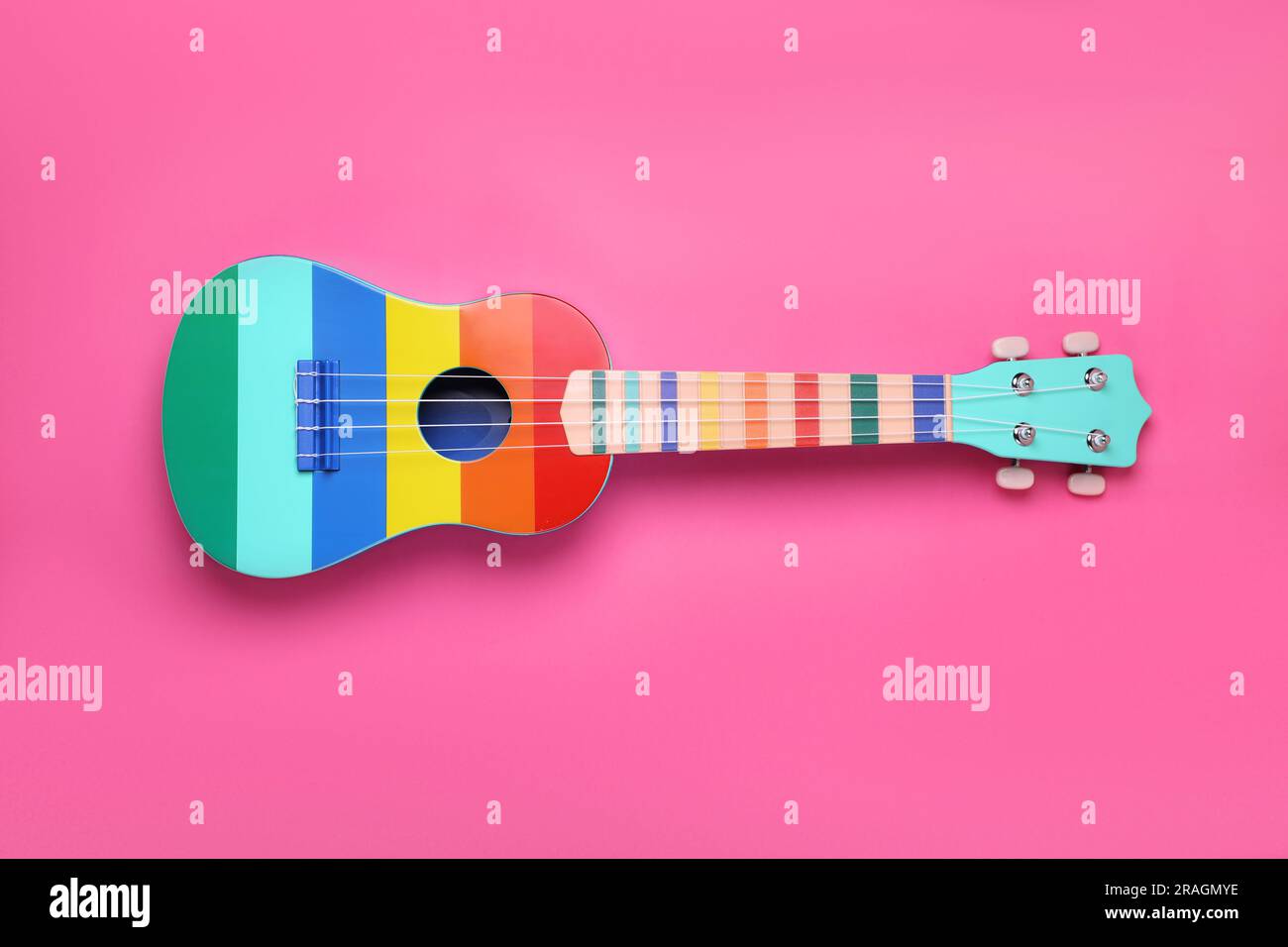 Colorful ukulele on pink background, top view. String musical ...