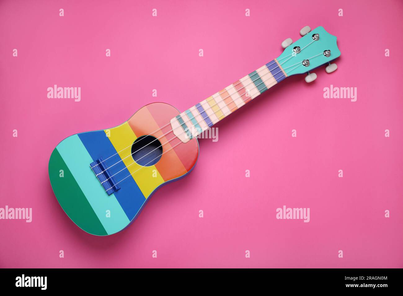 Colorful ukulele on pink background, top view. String musical ...