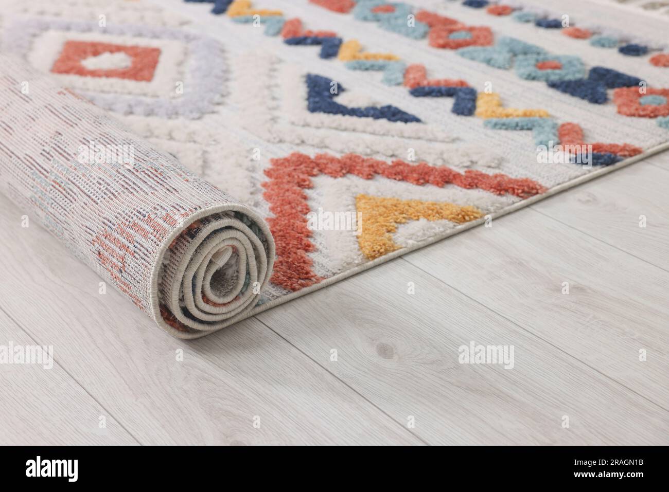 Rolled carpet with beautiful pattern on floor Stock Photo - Alamy
