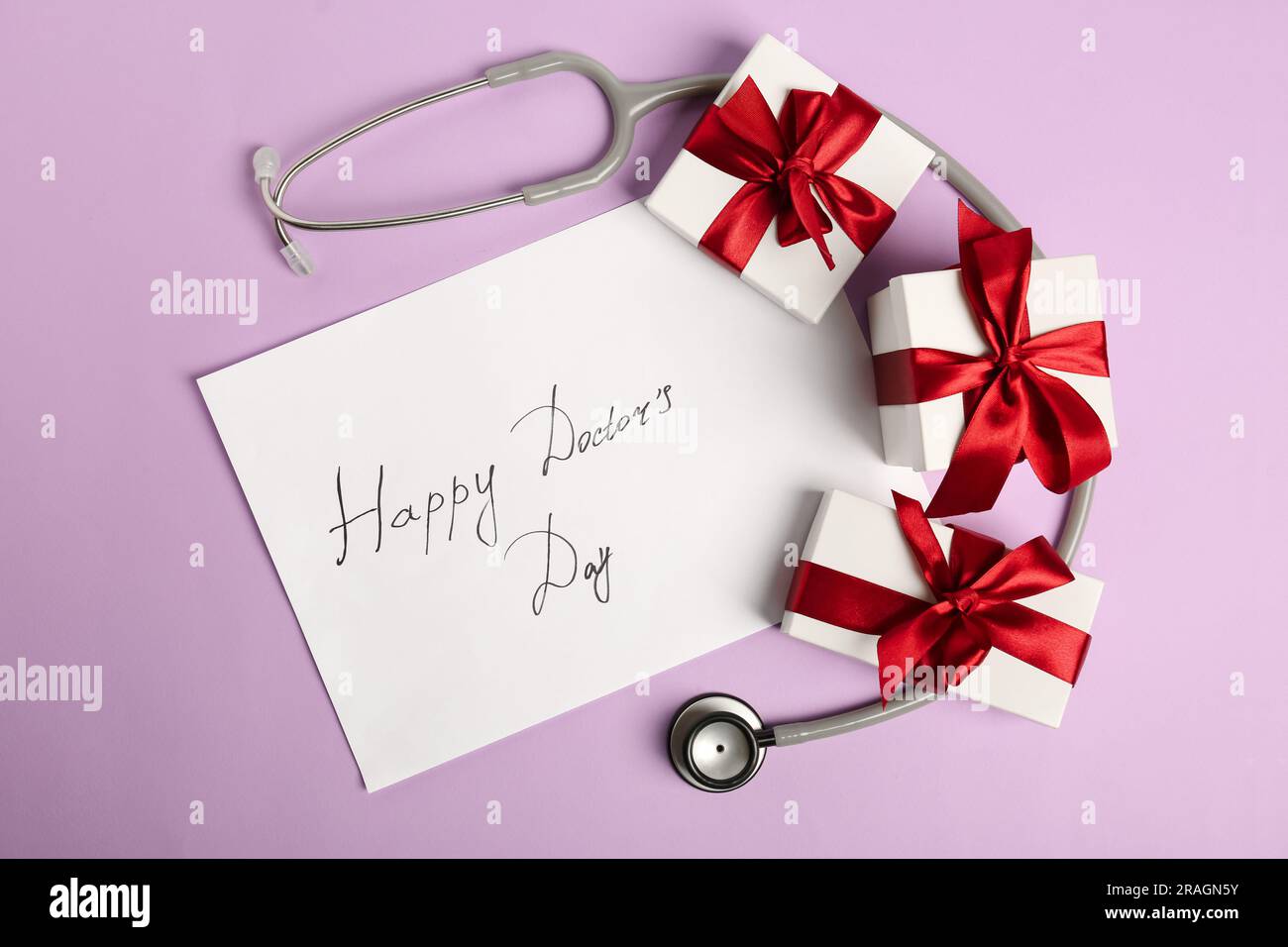 Card with phrase Happy Doctor's Day, stethoscope and gift boxes on ...