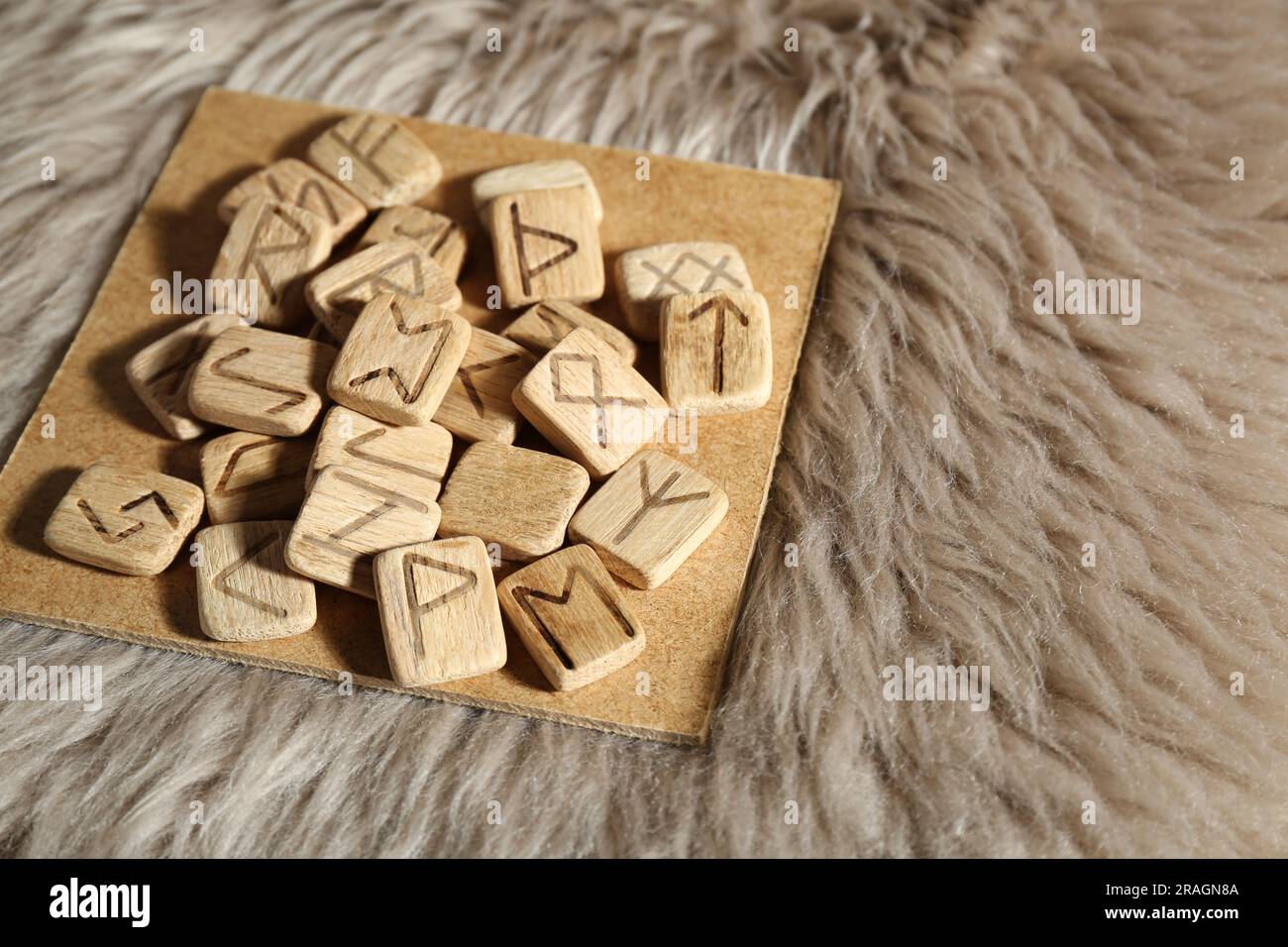 Many wooden runes on fur, closeup. Space for text Stock Photo - Alamy