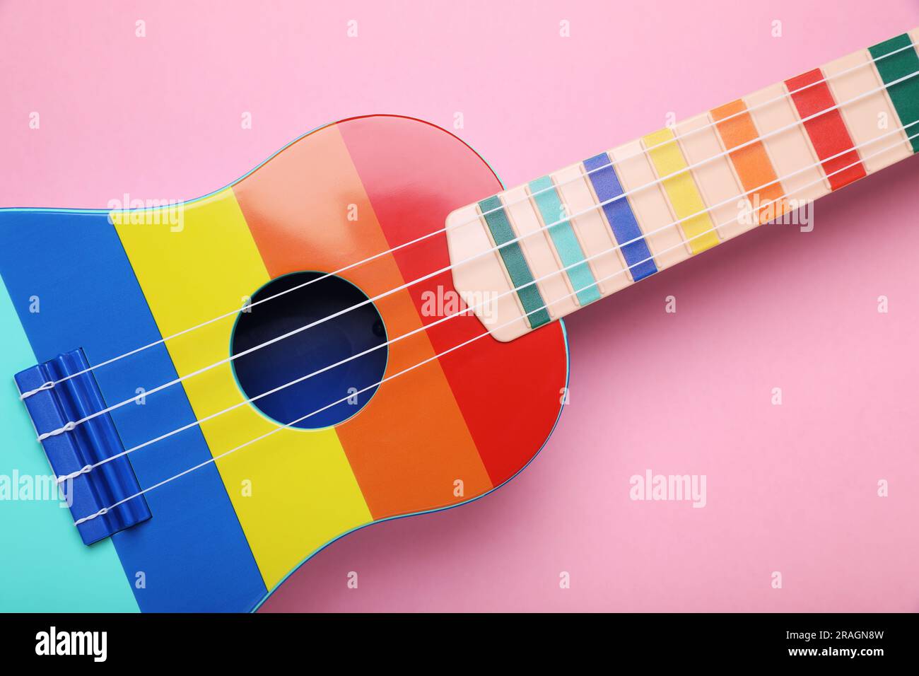 Colorful ukulele on pink background, top view. String musical ...