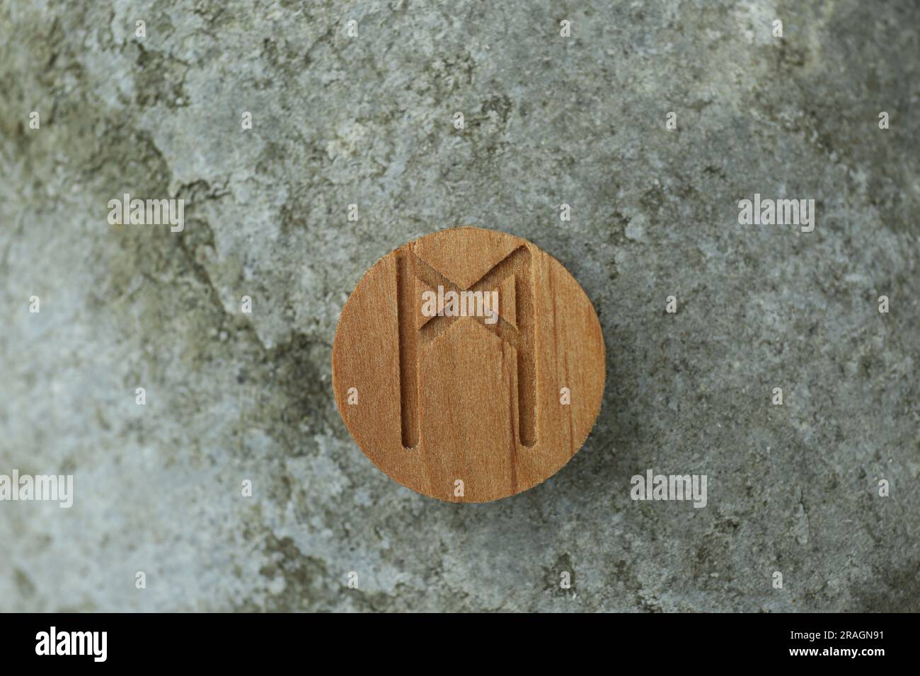 Wooden rune Mannaz on stone outdoors, closeup Stock Photo - Alamy