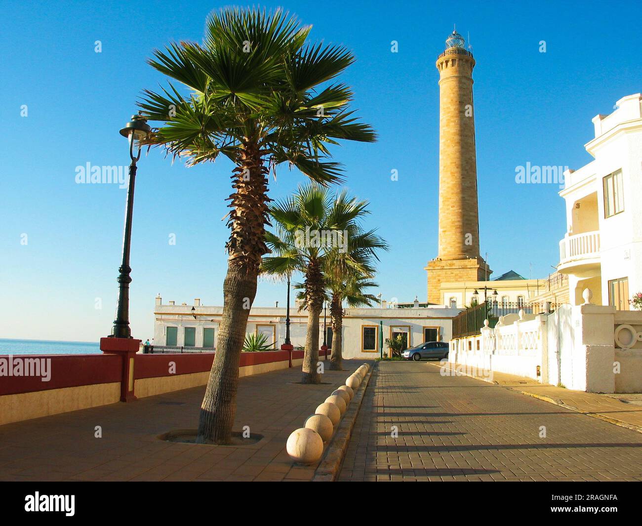 A lighthouse seen from the promenade in Chipiona, Spain, the highest ...