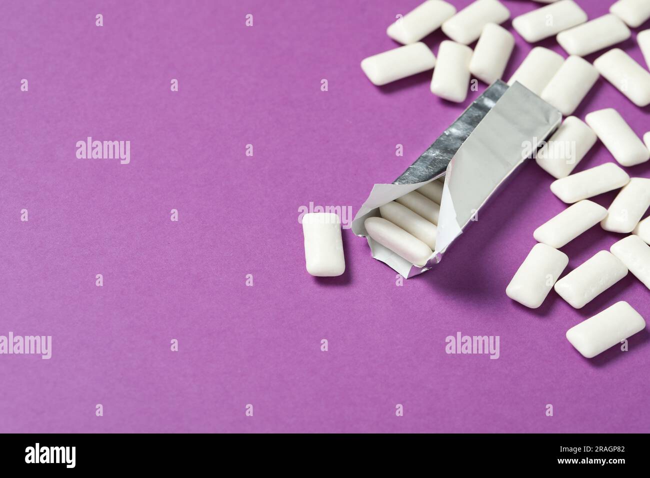Pack with tasty chewing gums on purple background, space for text Stock ...