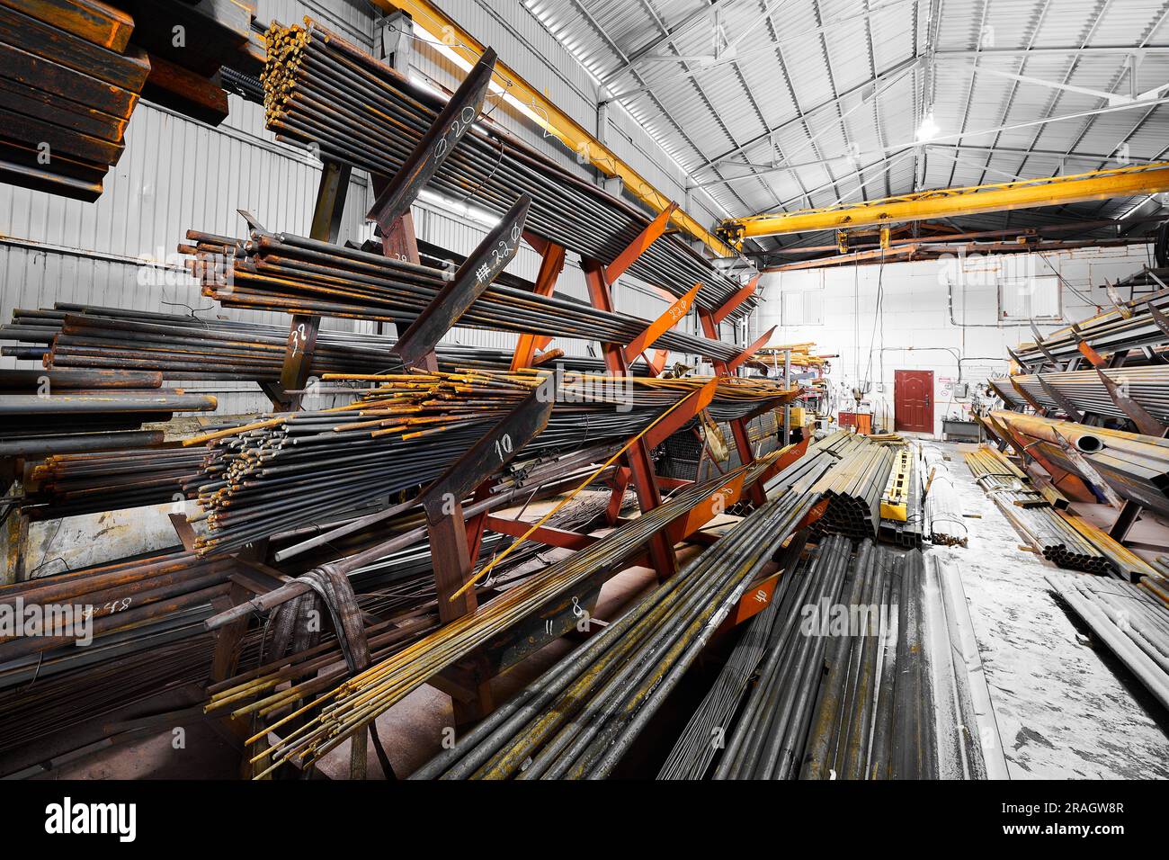 Thin metal rods stack on large rack in cold plant warehouse Stock Photo ...