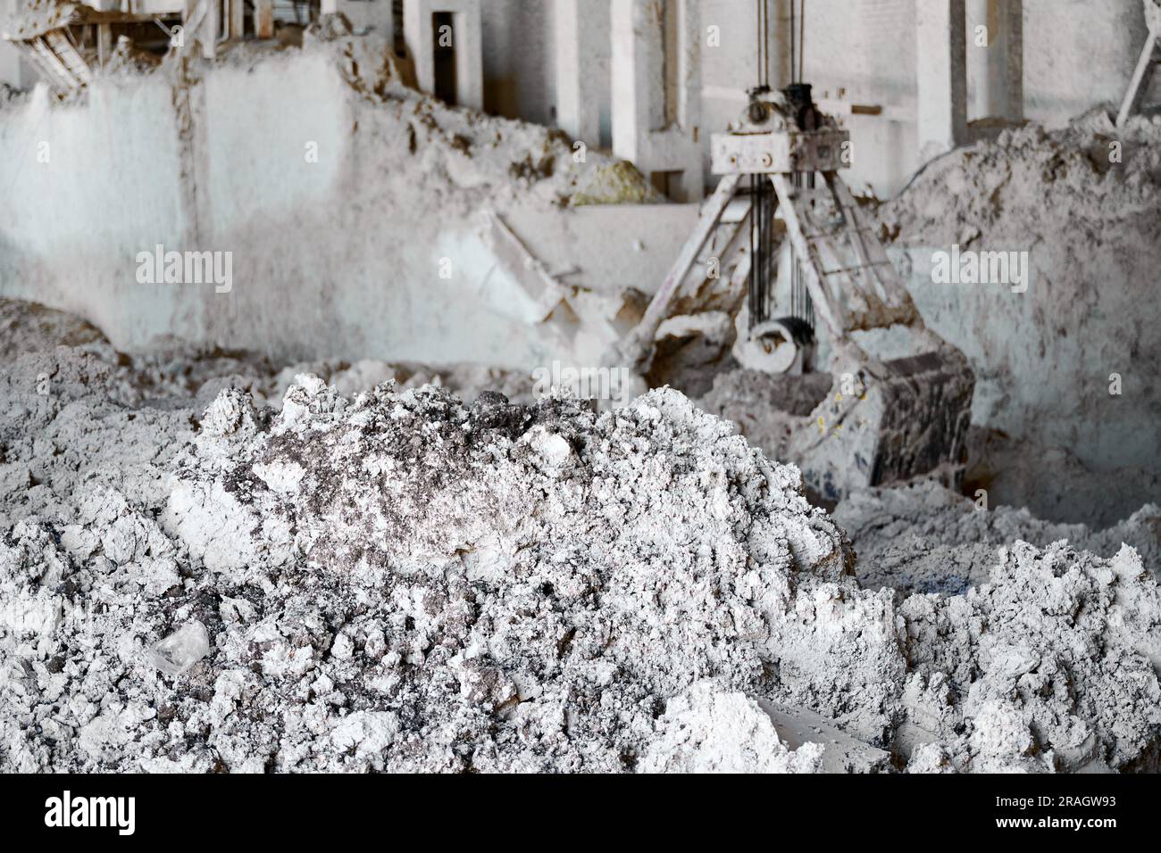 Grabber bucket operates at warehouse in pile of chalk Stock Photo - Alamy