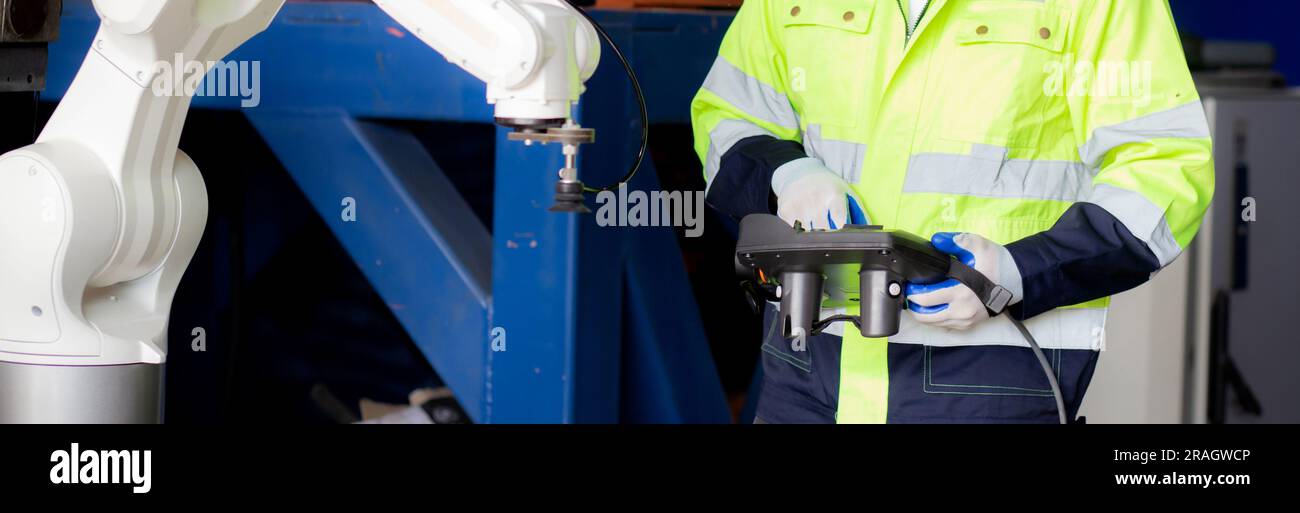 Young engineer man checking and maintenance machine robot arms ...