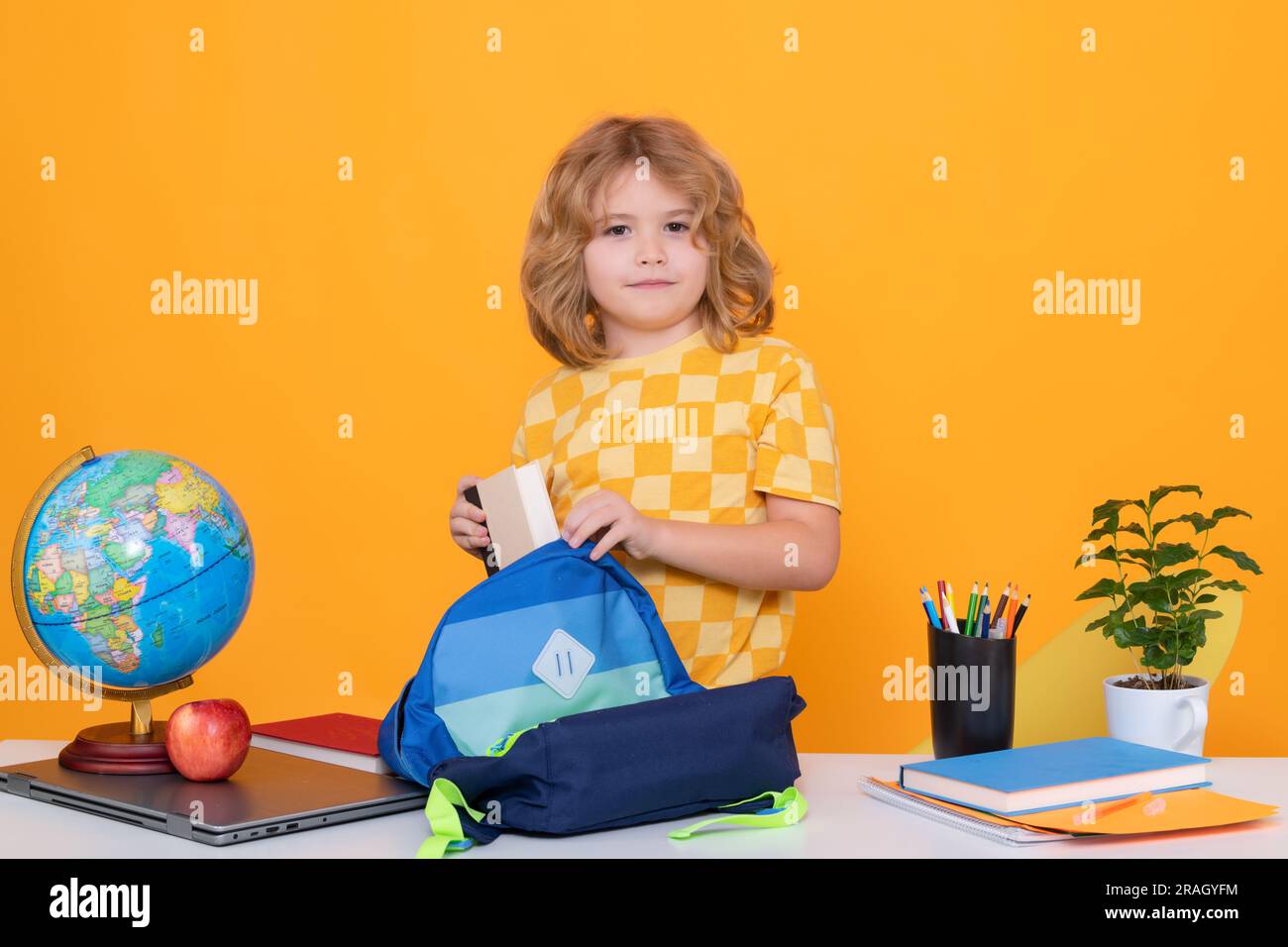 School child puts school supplies in a backpack. Preparation for school ...