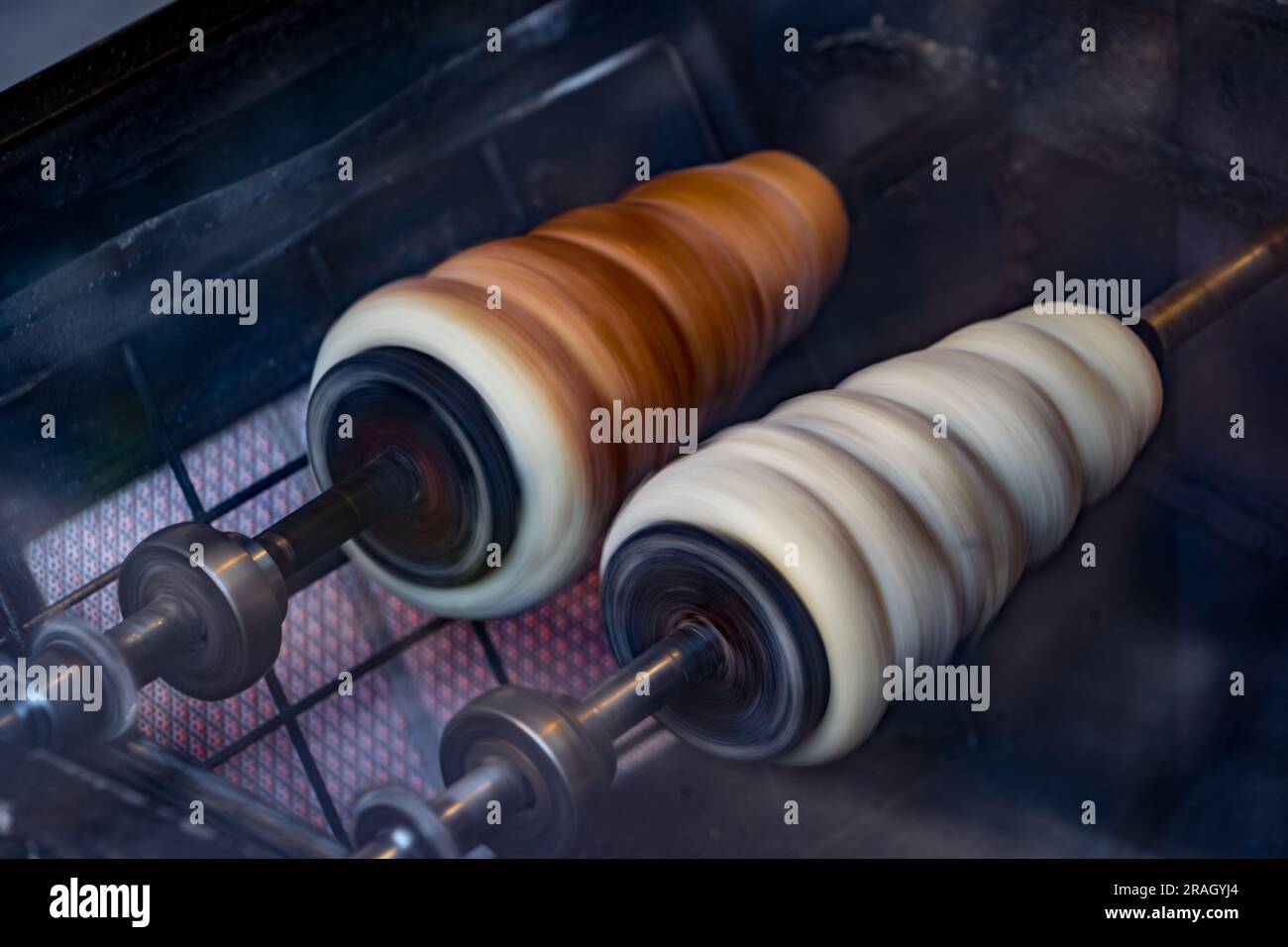 Fully baked and half baked chimney cake rolls at a market, popular ...