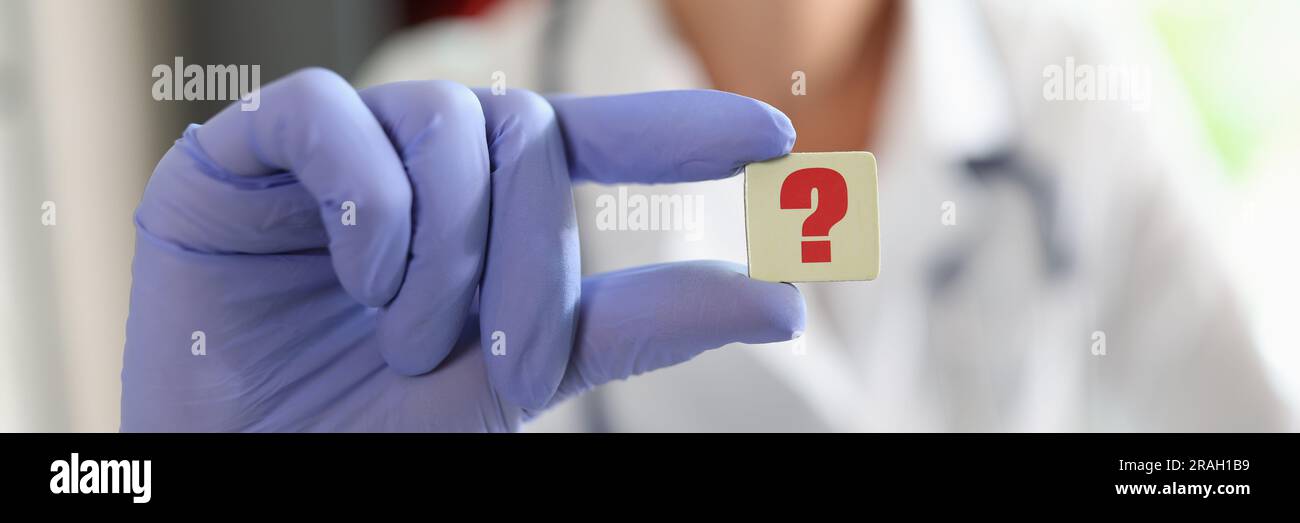 Female doctor hand in glove holding question mark sign Stock Photo - Alamy