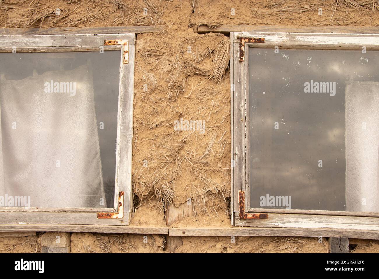 window on an old wall of a house made of clay in the countryside in ...