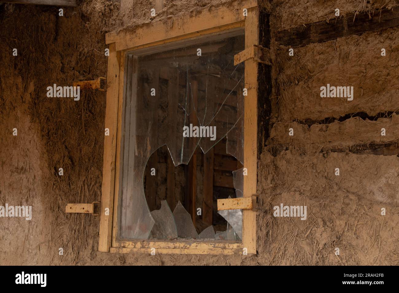 window on an old wall of a house made of clay in the countryside in ...
