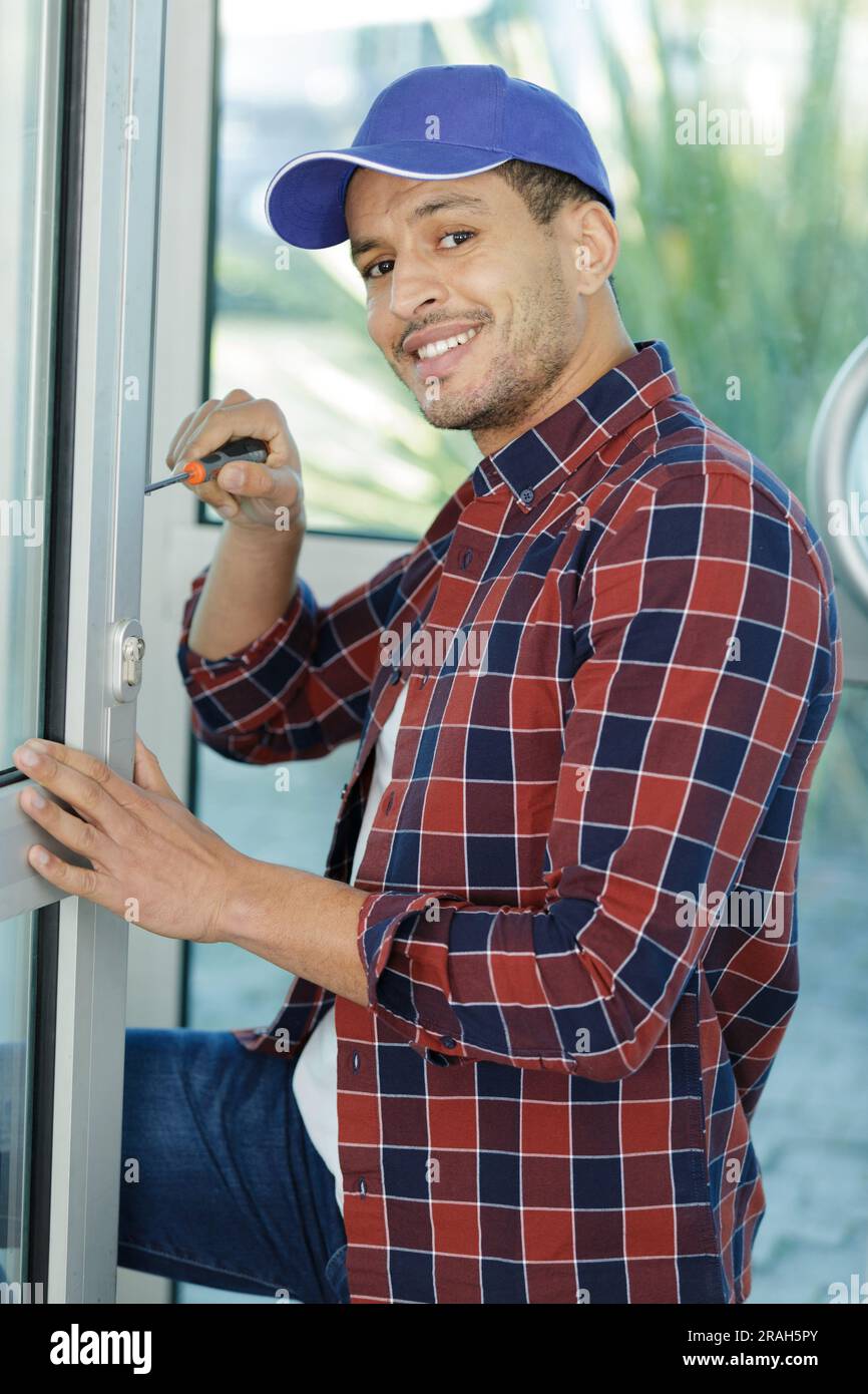 worker fasten the handle to a plastic window Stock Photo - Alamy