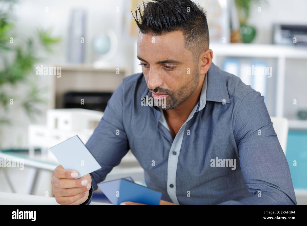 male interior designer working at desk planning color charts Stock ...