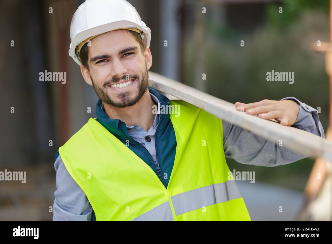man as builder carrying wood and working Stock Photo - Alamy
