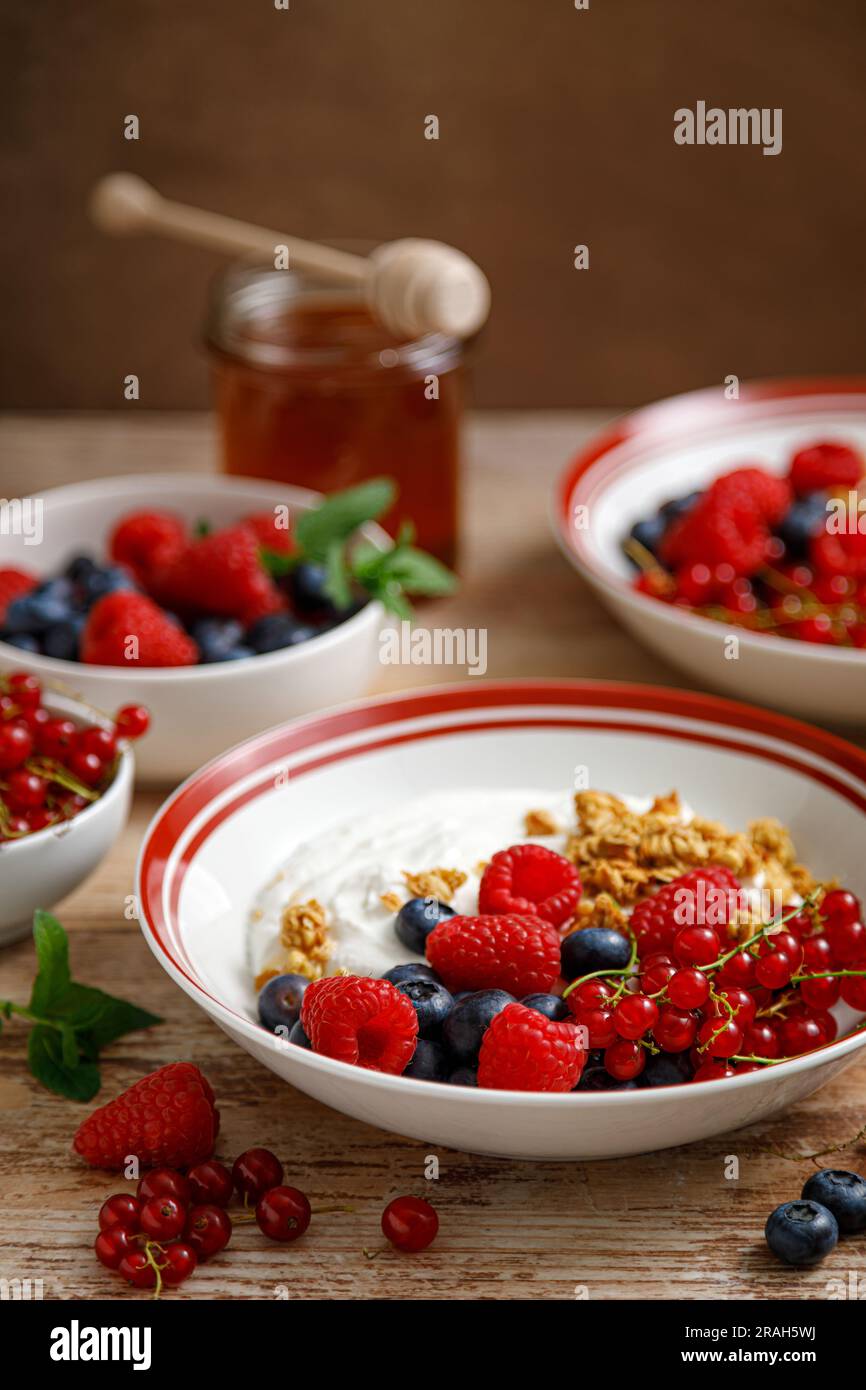 Yogurt with berries on wooden background. White plain greek yogurt with ...