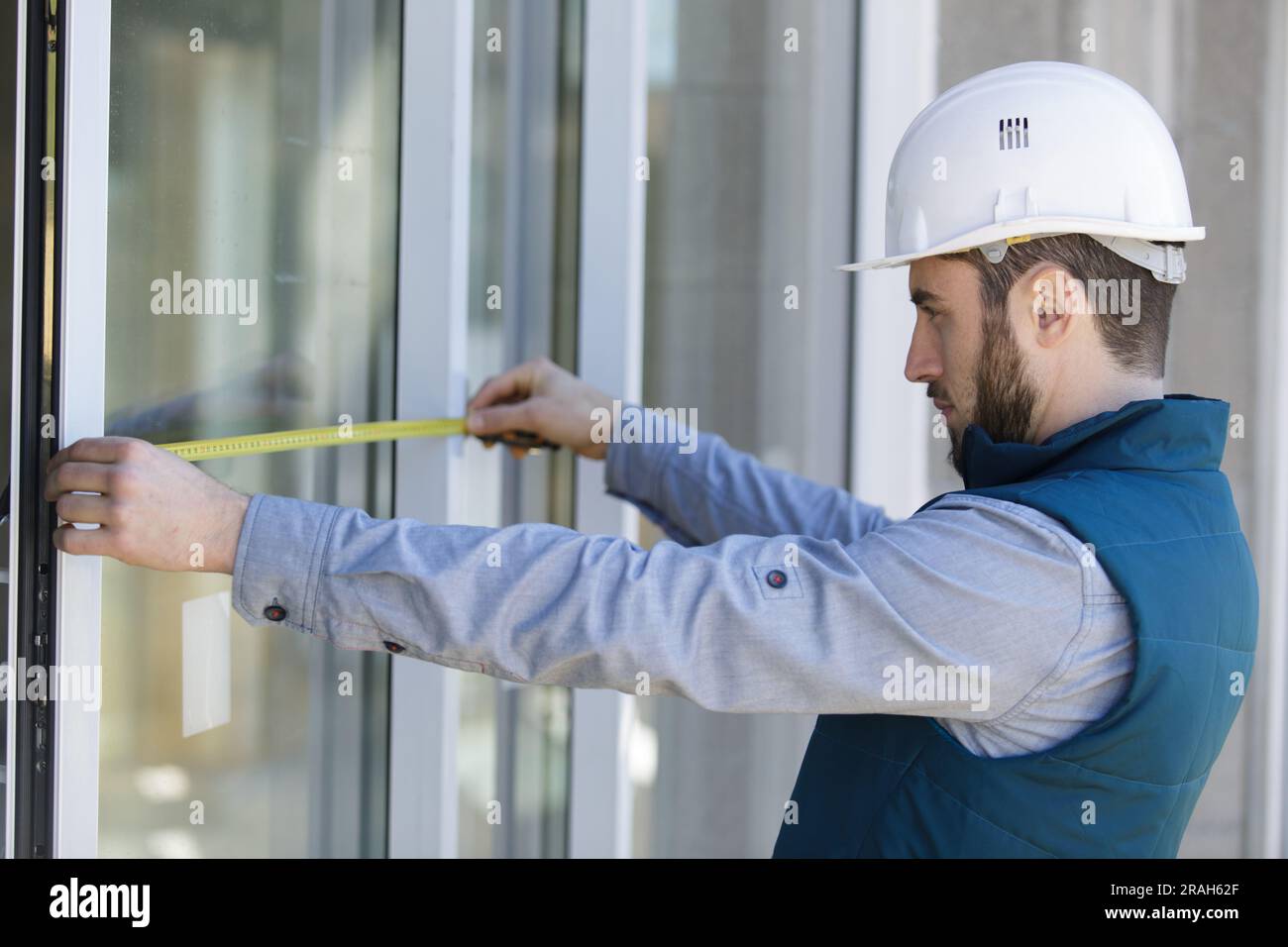 builder measuring window prior to installation Stock Photo - Alamy