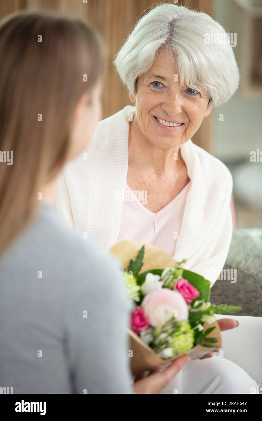 daughter giving flowers to mother Stock Photo - Alamy