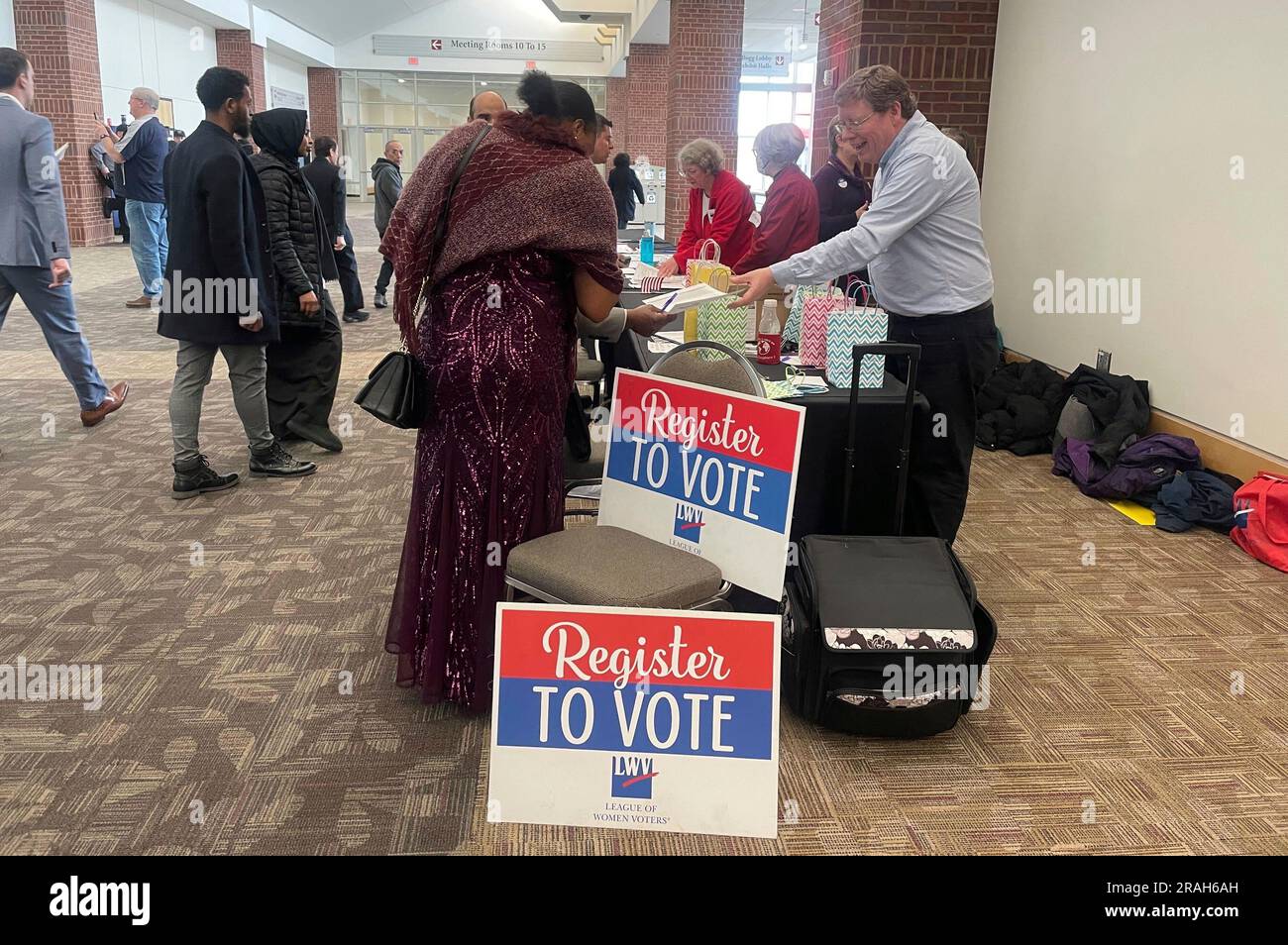 People approach a table where they can register to vote after becoming ...