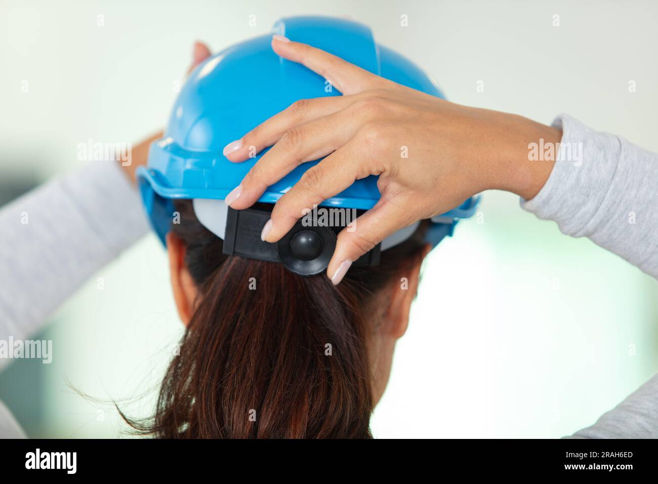 young female adjusting her safety helmet hardhat Stock Photo - Alamy