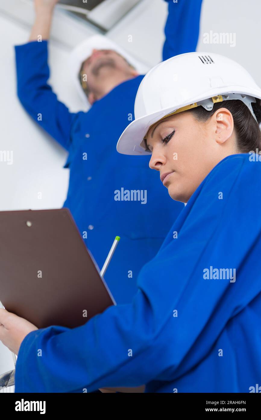 two electricians working in building ceiling Stock Photo - Alamy