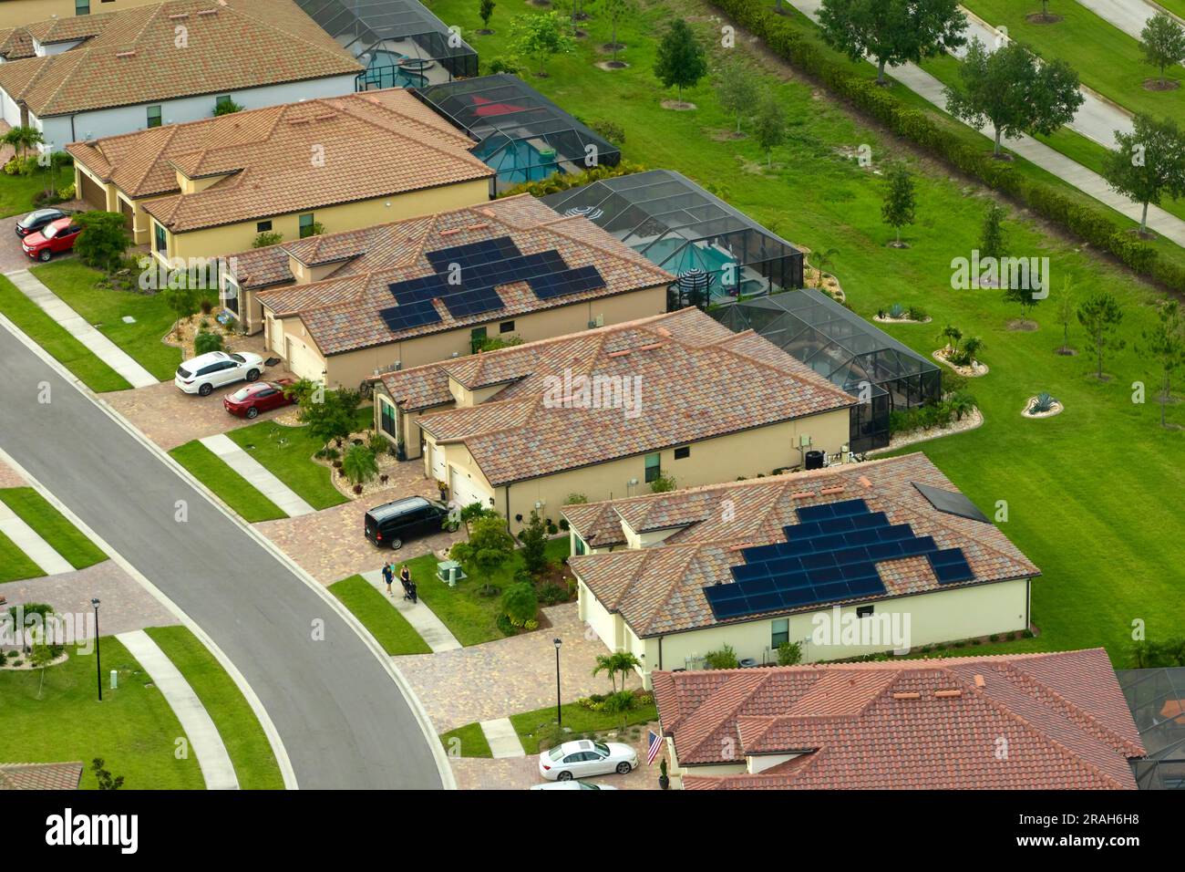 Aerial view of tightly located family houses with solar panels on roofs ...