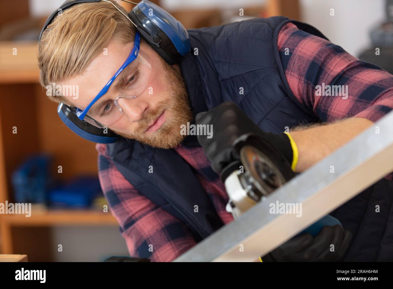 man using angle grinder on metal length Stock Photo - Alamy