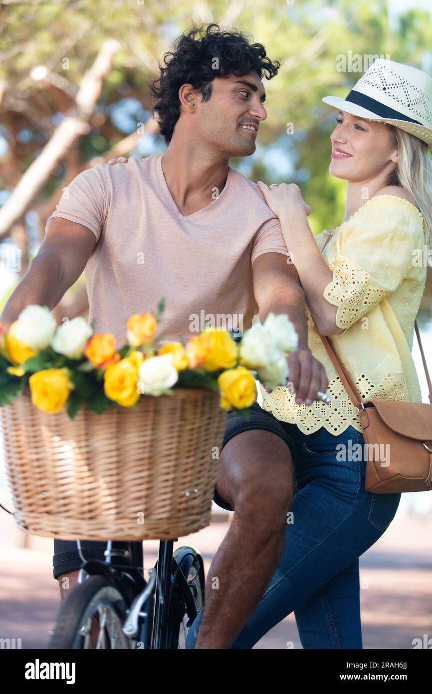 happy couple chasing each other on bike Stock Photo - Alamy