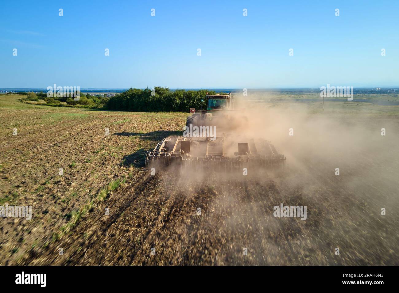 Aerial view of tractor plowing agriculural farm field preparing soil ...