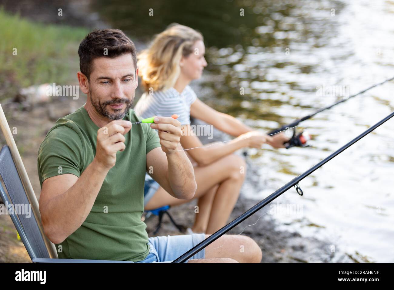 couple fishing man putting bait on the line Stock Photo - Alamy