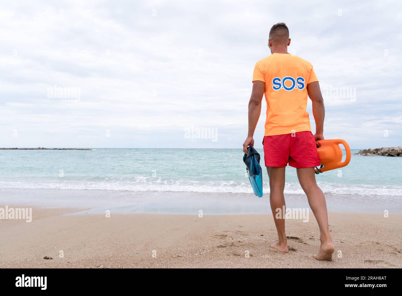 Photo with copy space of the rear view of a lifeguard walking with a ...